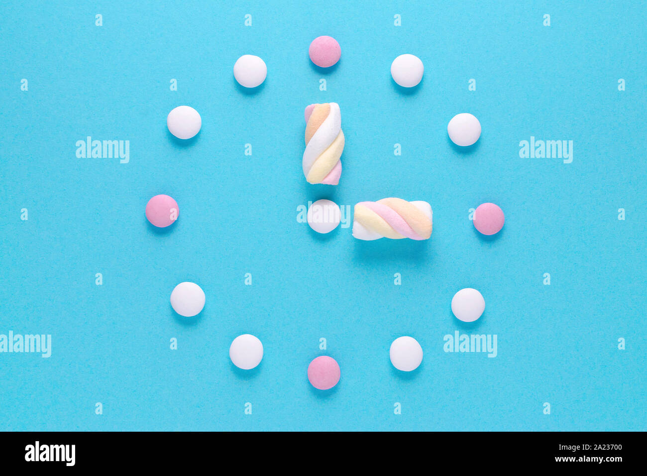 concept image, a clock with candy and marshmallow on blue Stock Photo ...