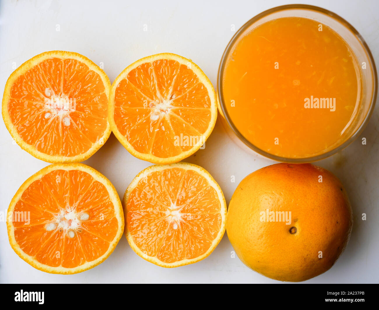 glass of orange juice viewed from above with halves of the fruit and a ...