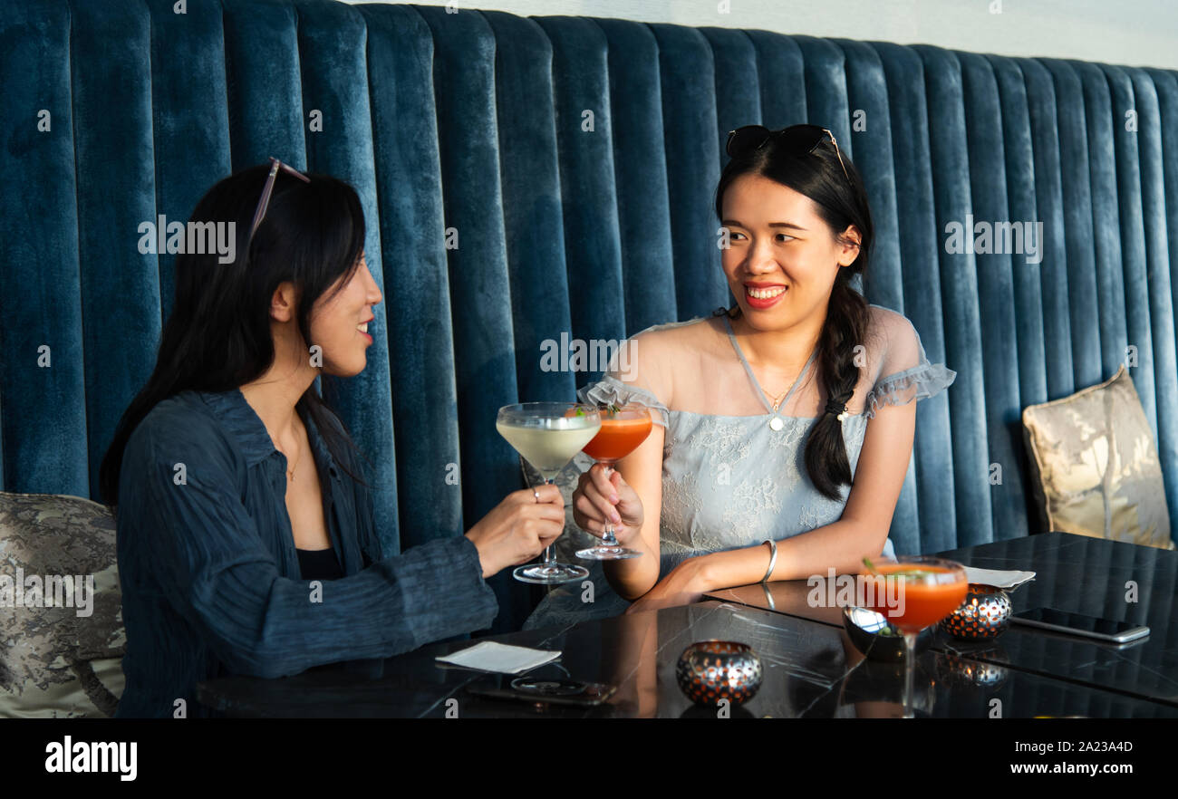 Asian girls toasting with cocktails at the bar Stock Photo - Alamy