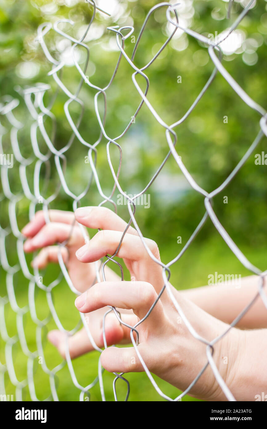 Hands holding fence outdoors in the daytime, in a village Stock Photo ...