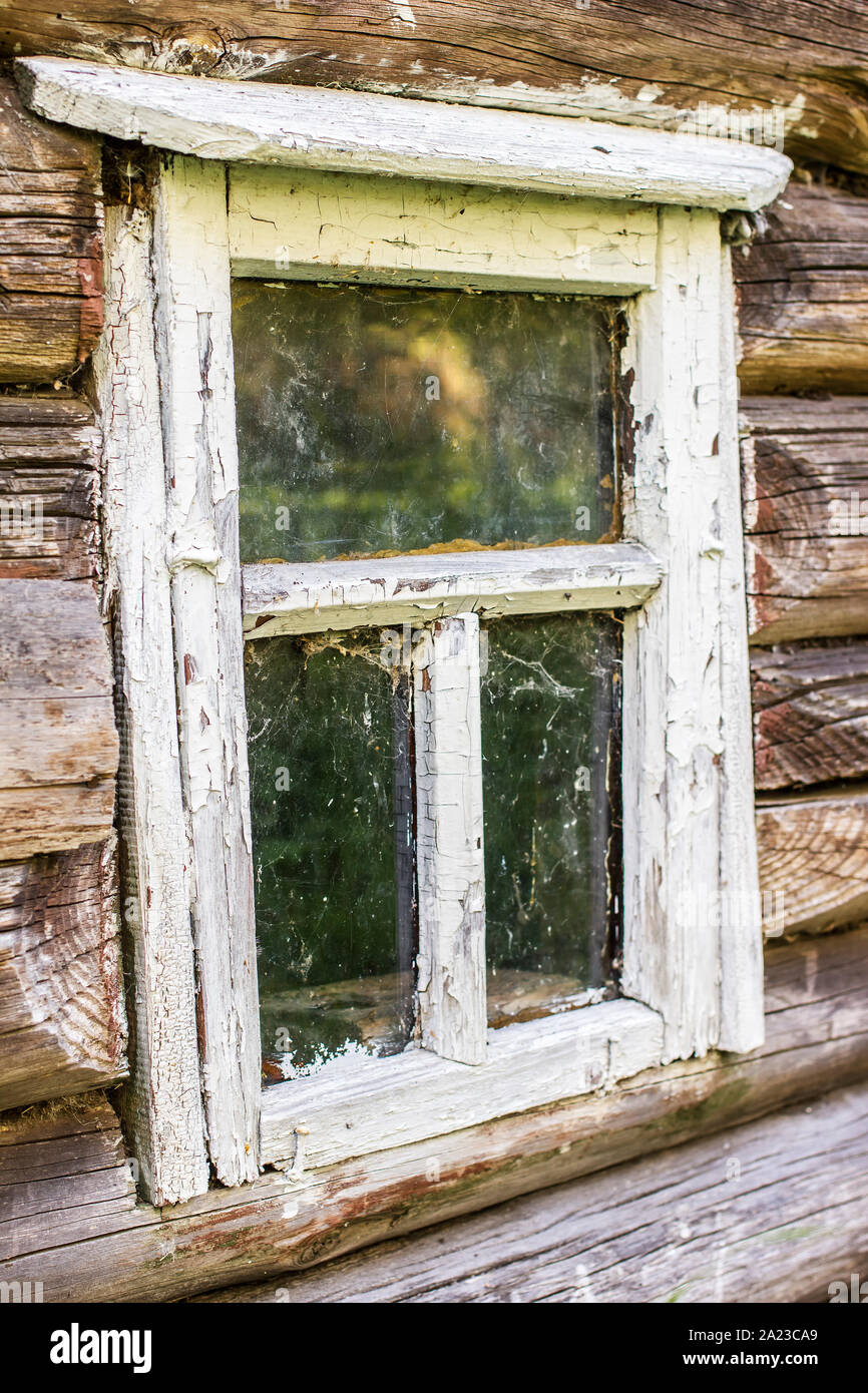 old wooden window with peeling white paint in an ancient a log cabin in ...