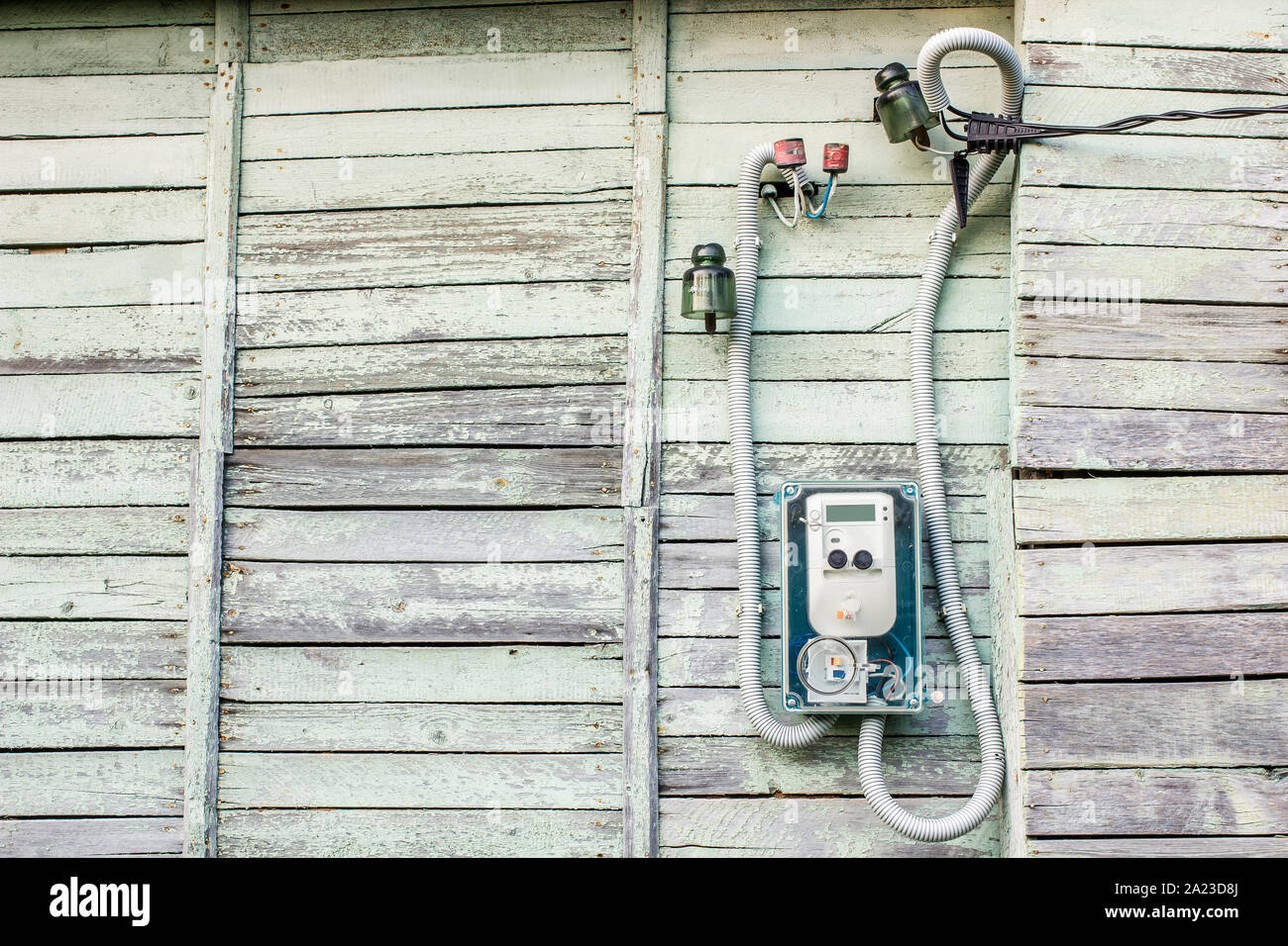 Modern electrical meter hanging on the old wooden house in the village ...