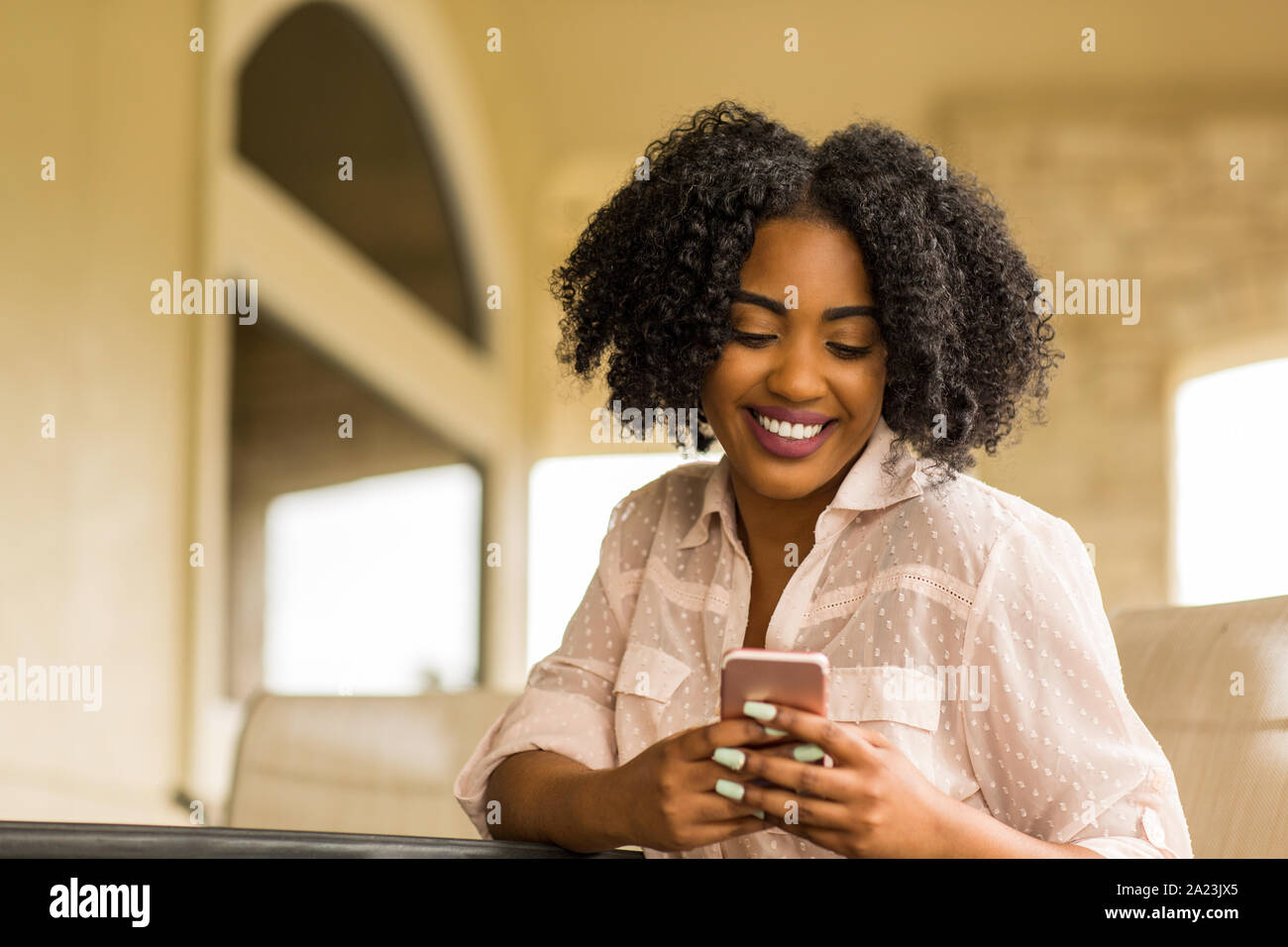Happy African American woman texting and talking Stock Photo - Alamy