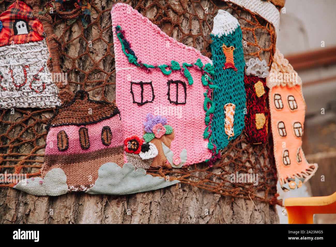 handmade decoration of knitted houses around the tree trunk over the ...