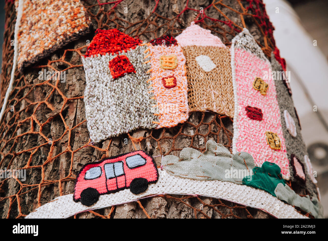 handmade decoration of knitted houses around the tree trunk over the ...