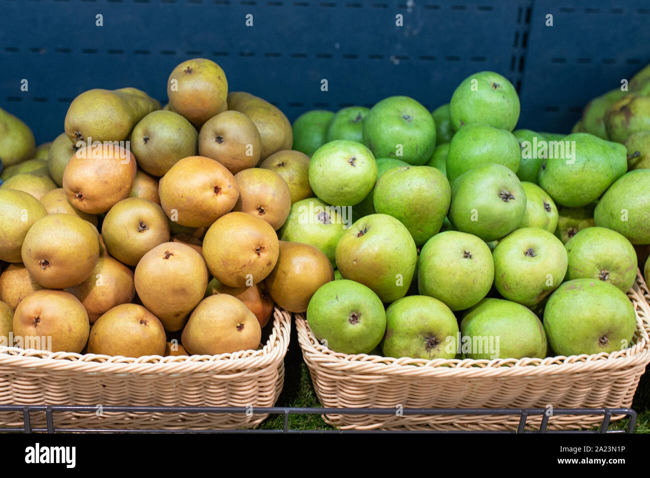 Yellow and green pears on a shelf of the refrigerator, in a supermarket ...