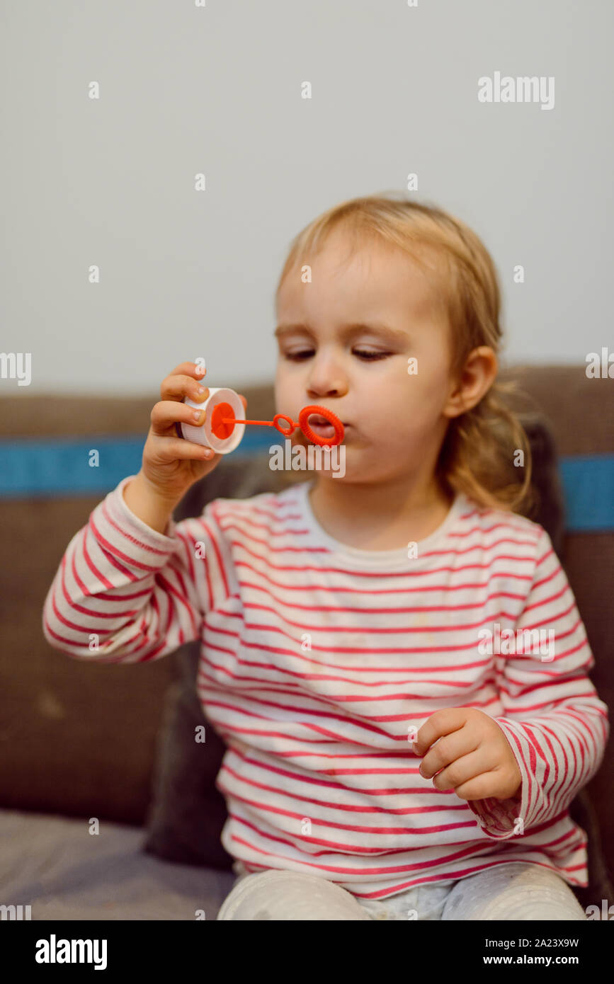 little girl doing bubbles in the livingroom. One year old Stock Photo ...
