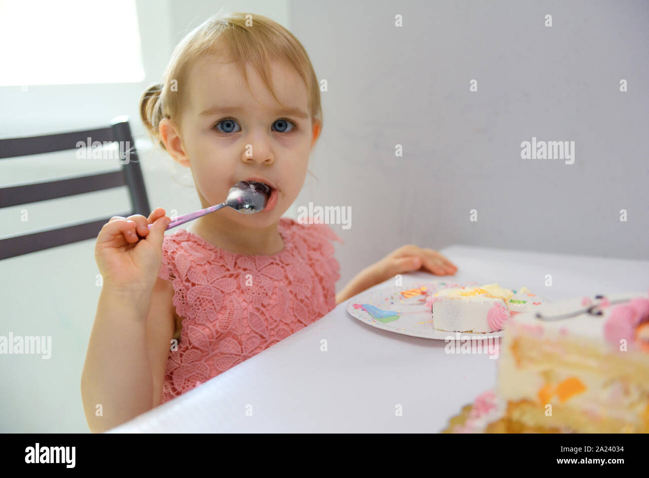 Baby girl 1 year old eating birthday cake in room. Birthday party ...