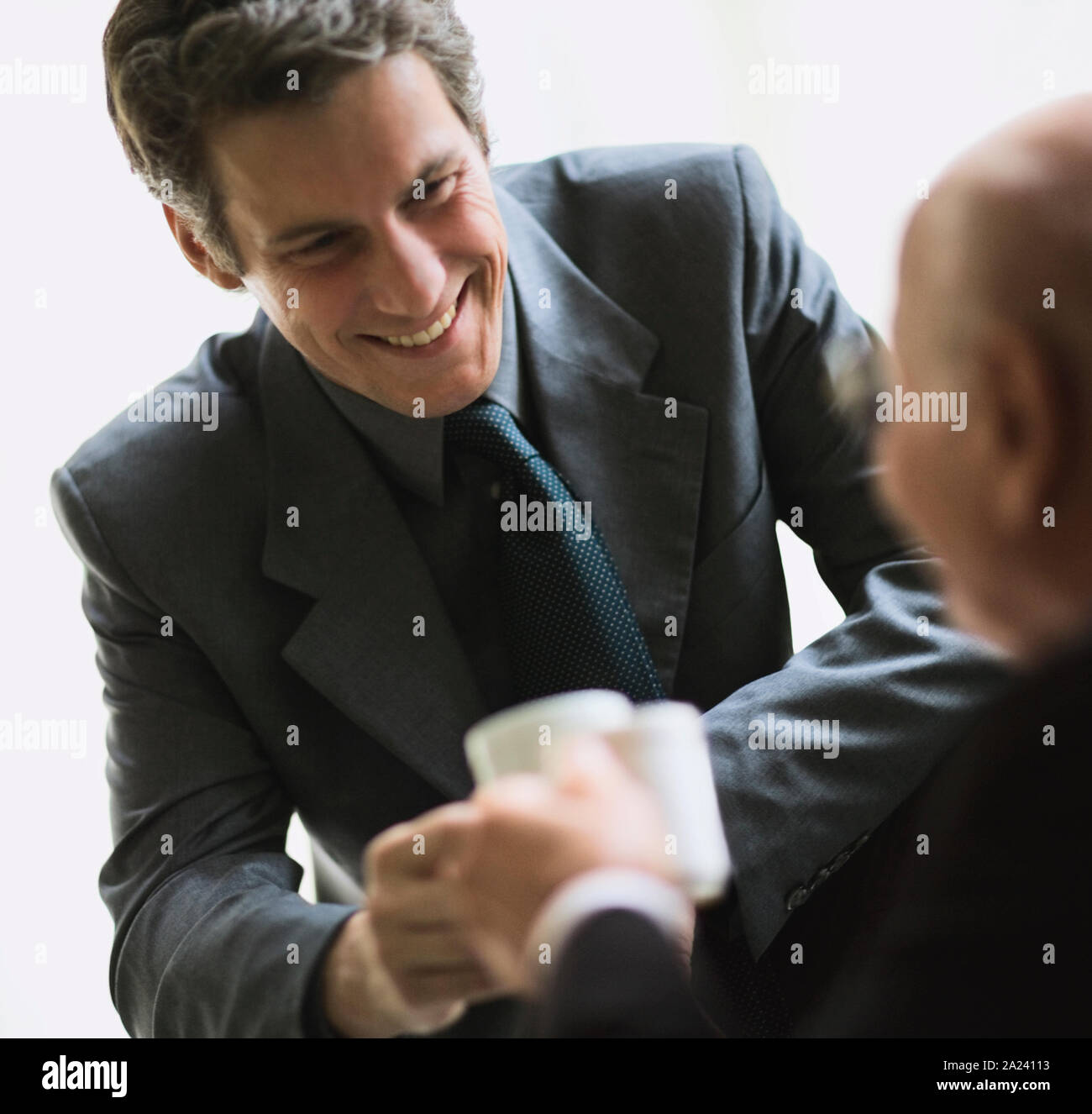 View of two men engaged in a friendly conversation Stock Photo - Alamy