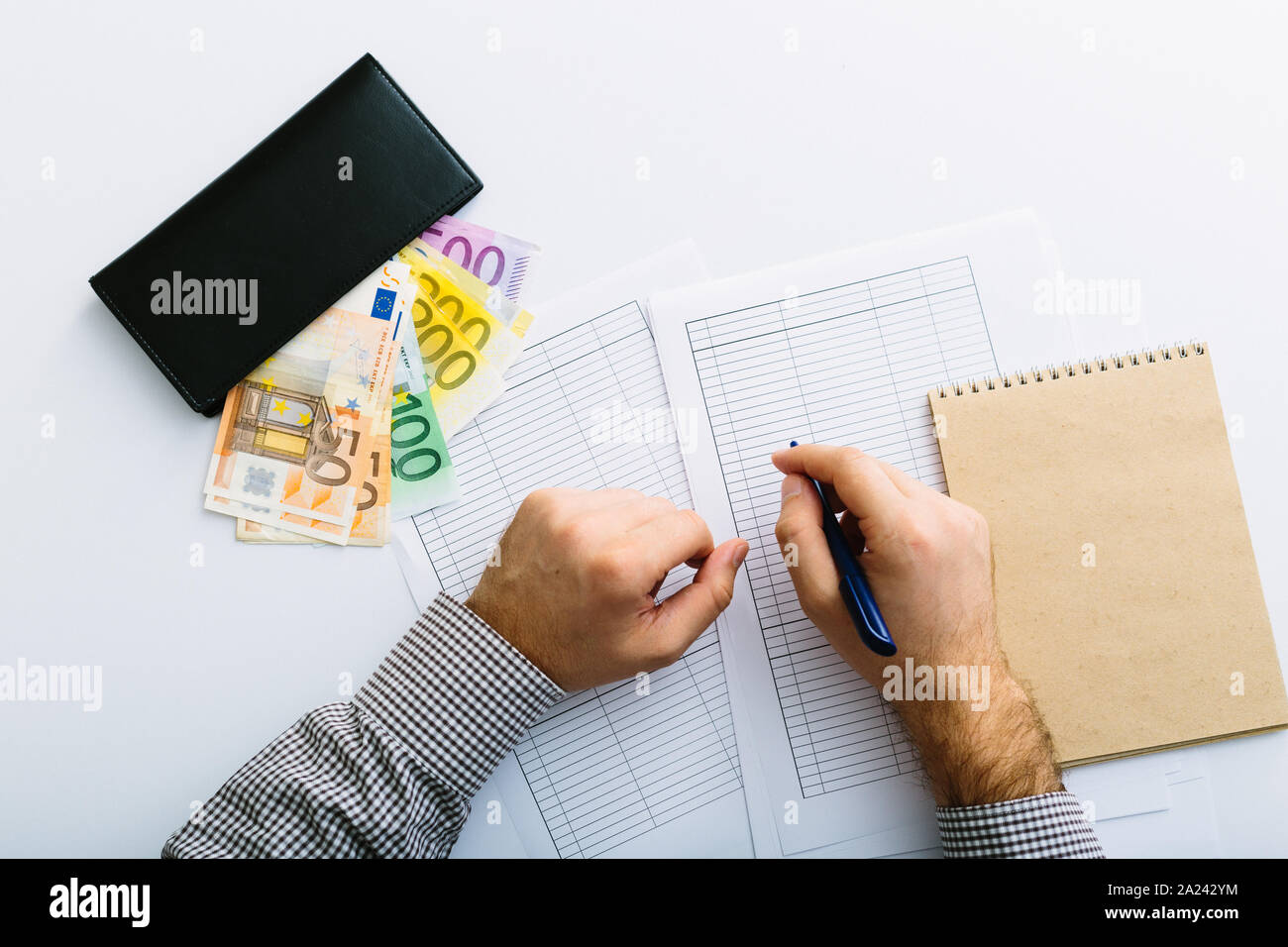 Euro banknotes are stacked. Man doing his accounting. Distribution of ...