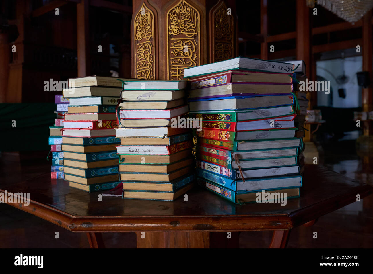 Colorful Islamic prayer books piled in the main wood interior of the ...