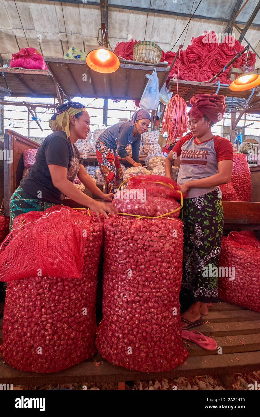 Women busy sorting and selling red onions in the vegetable section at ...