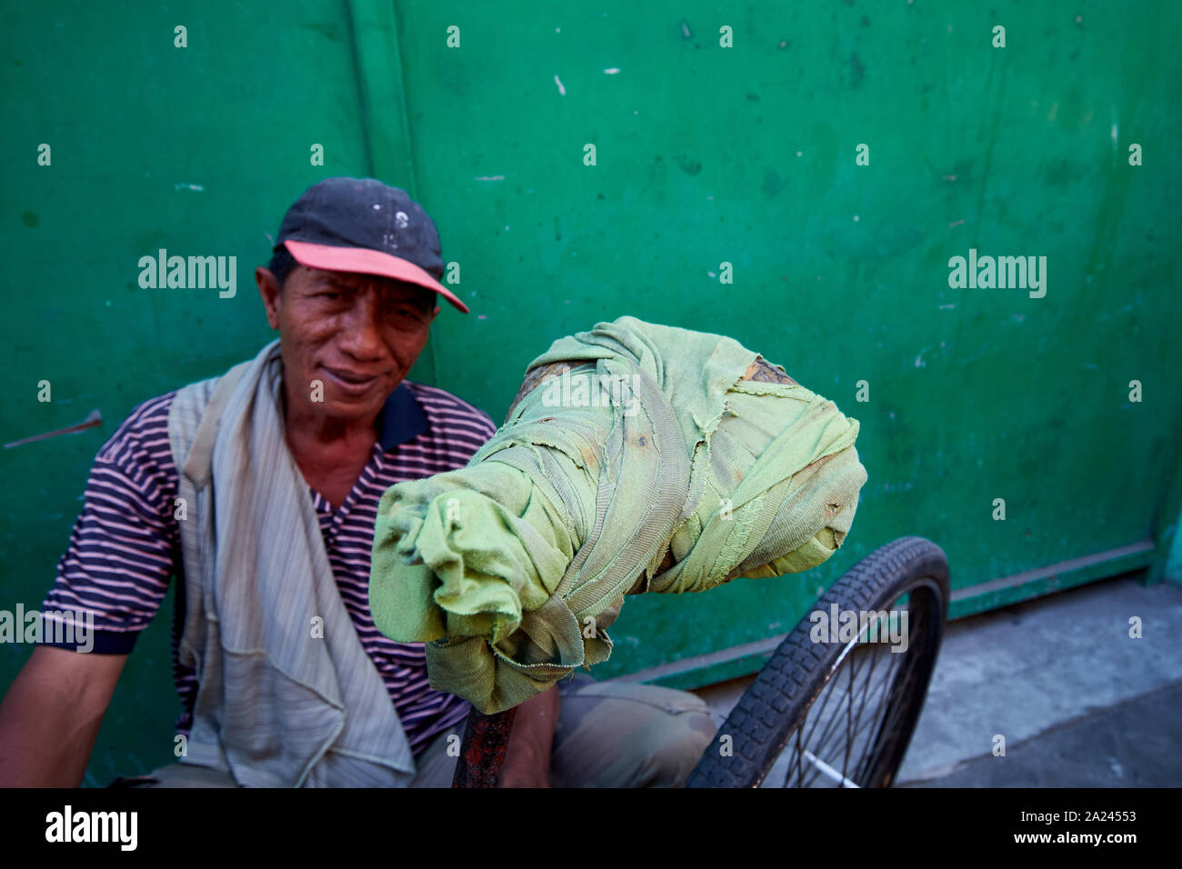 A rider shows off his handmade, cloth strip repair job of his bicycle ...