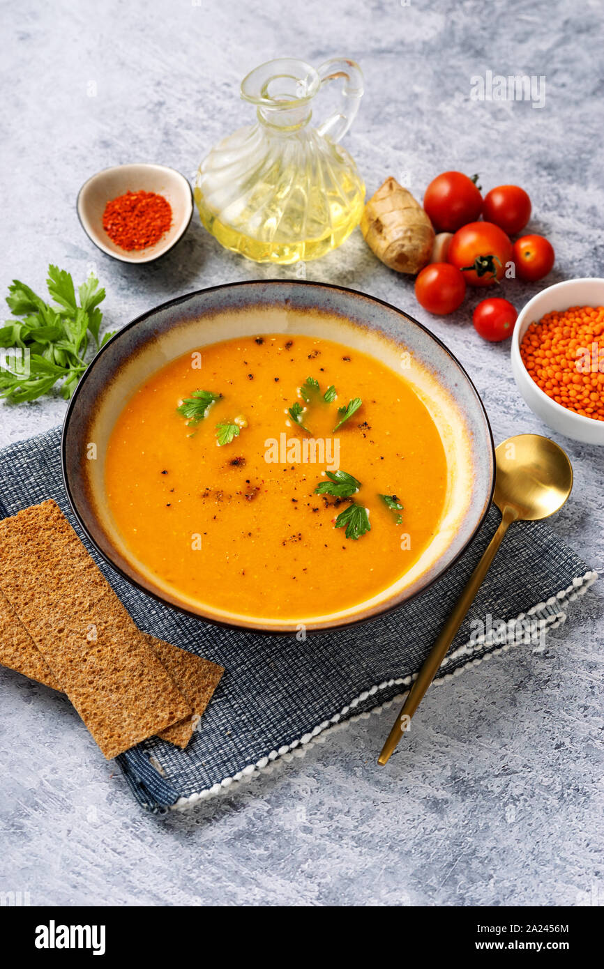 Winter hot and spicy lentil cream soup on light blue background ...