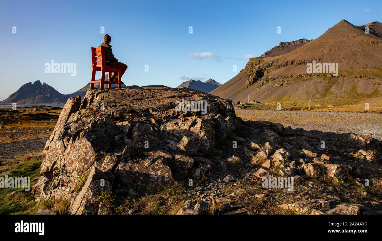 Tourist in a random red chair along the highway in southern Iceland ...