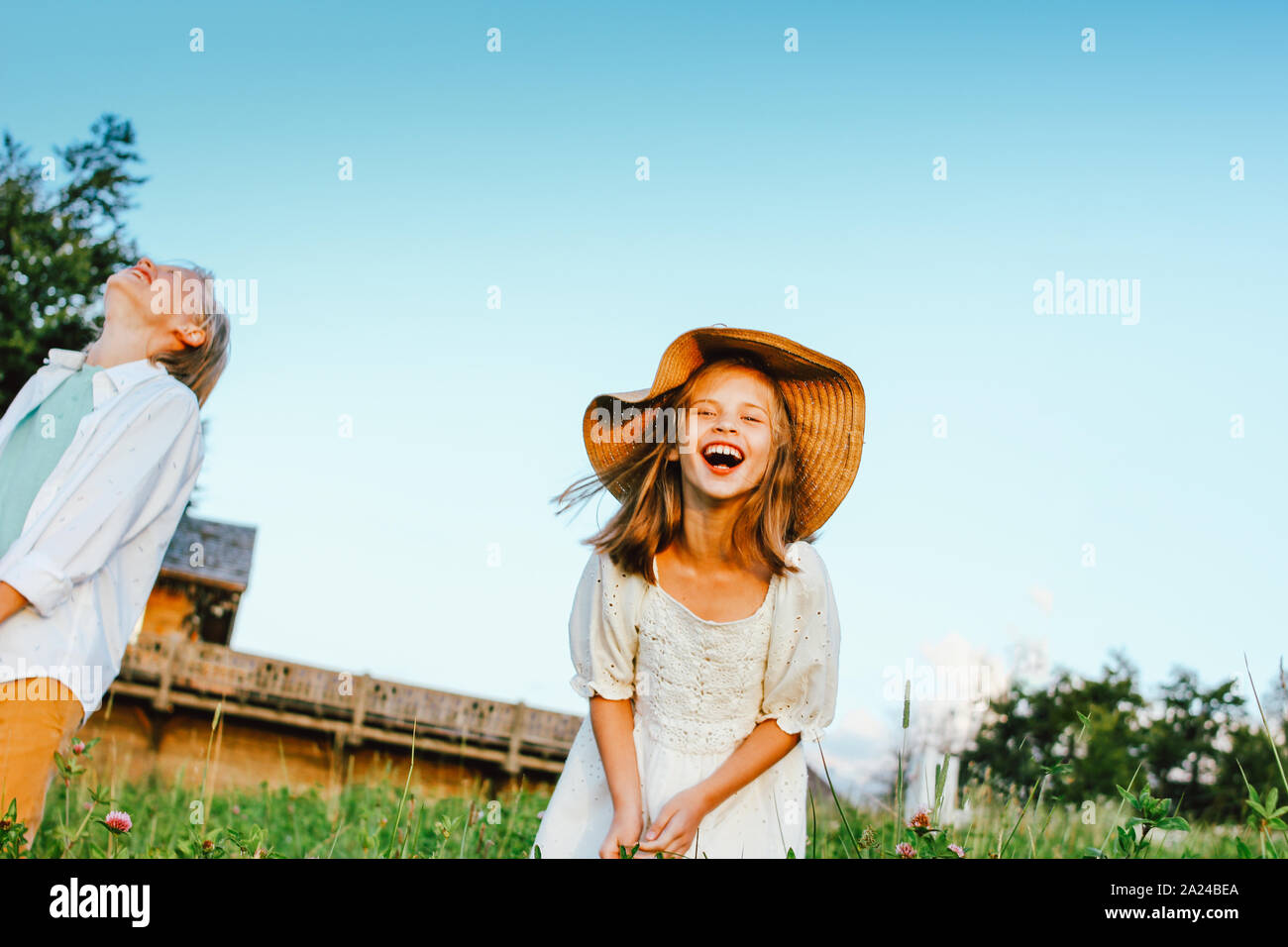 Laughing children brother and sister friends in grass on the background ...