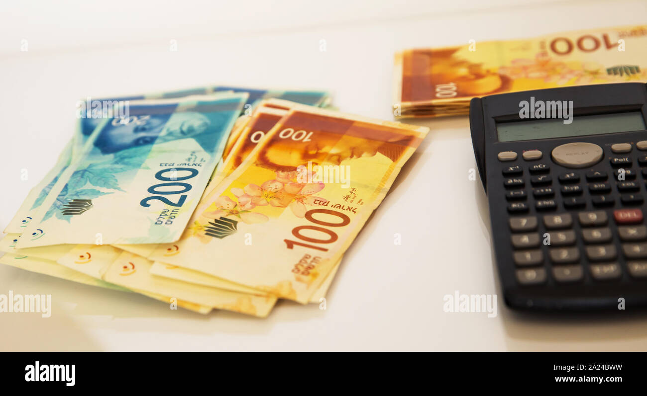 Israeli New Sheqel and calculator on white background Stock Photo - Alamy