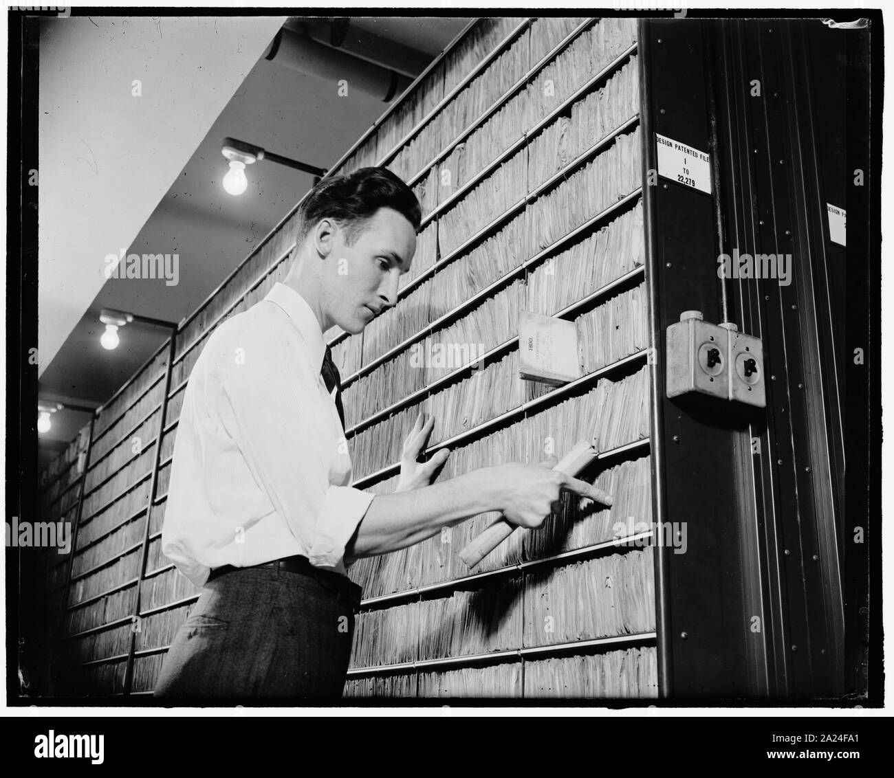 Patent Office employee pointing to copies of first patent granted after ...