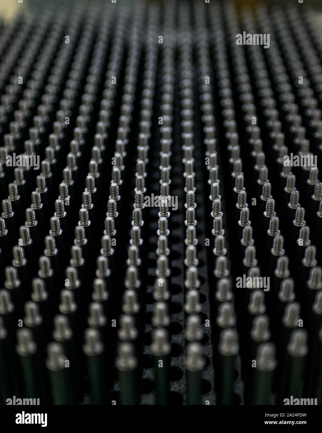 Close up shot of black screw thread bolts rowed up to a pattern ...