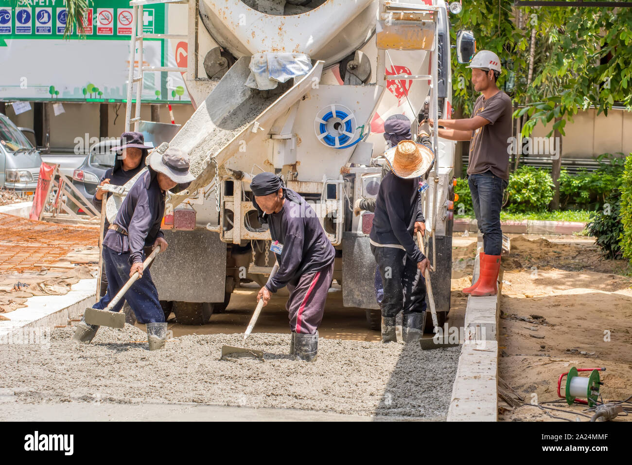 Construction worker pouring cement for doing the road Stock Photo - Alamy