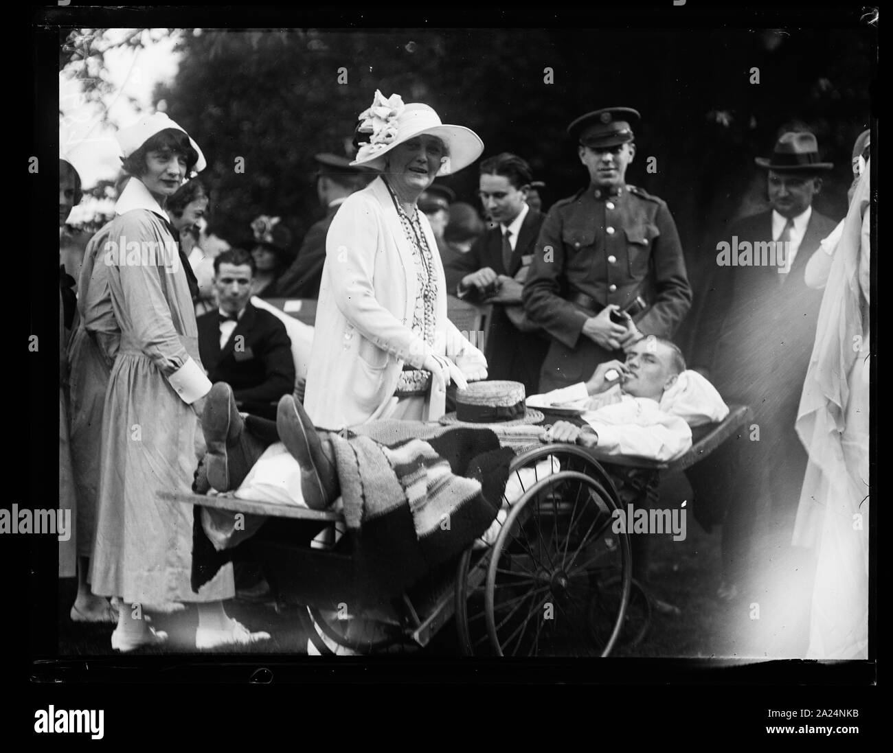 People gathered with wounded person in wheelchair Stock Photo - Alamy