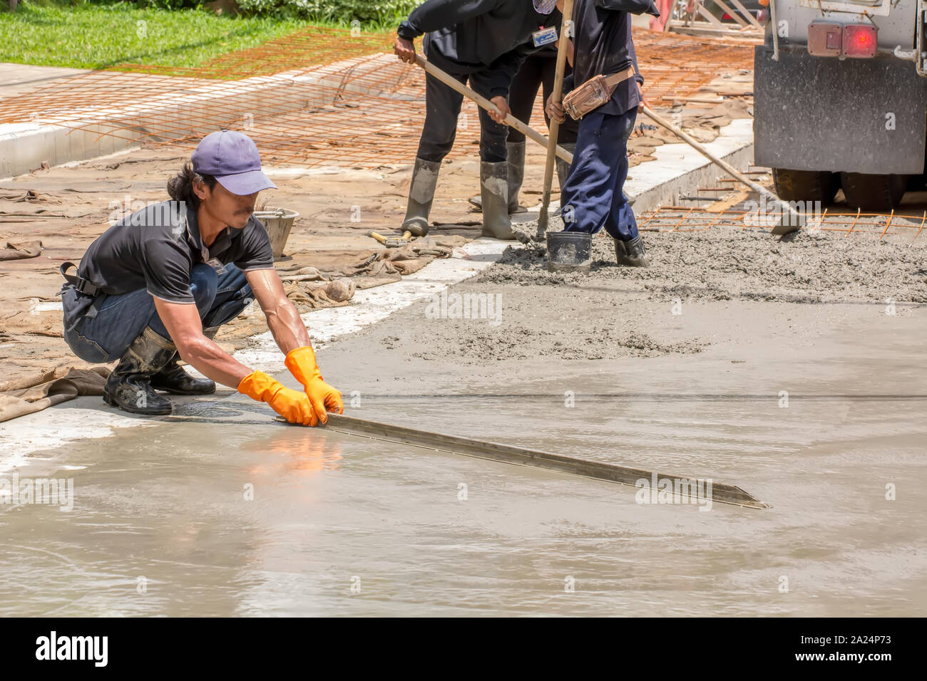 Construction worker pouring cement for doing the road Stock Photo - Alamy