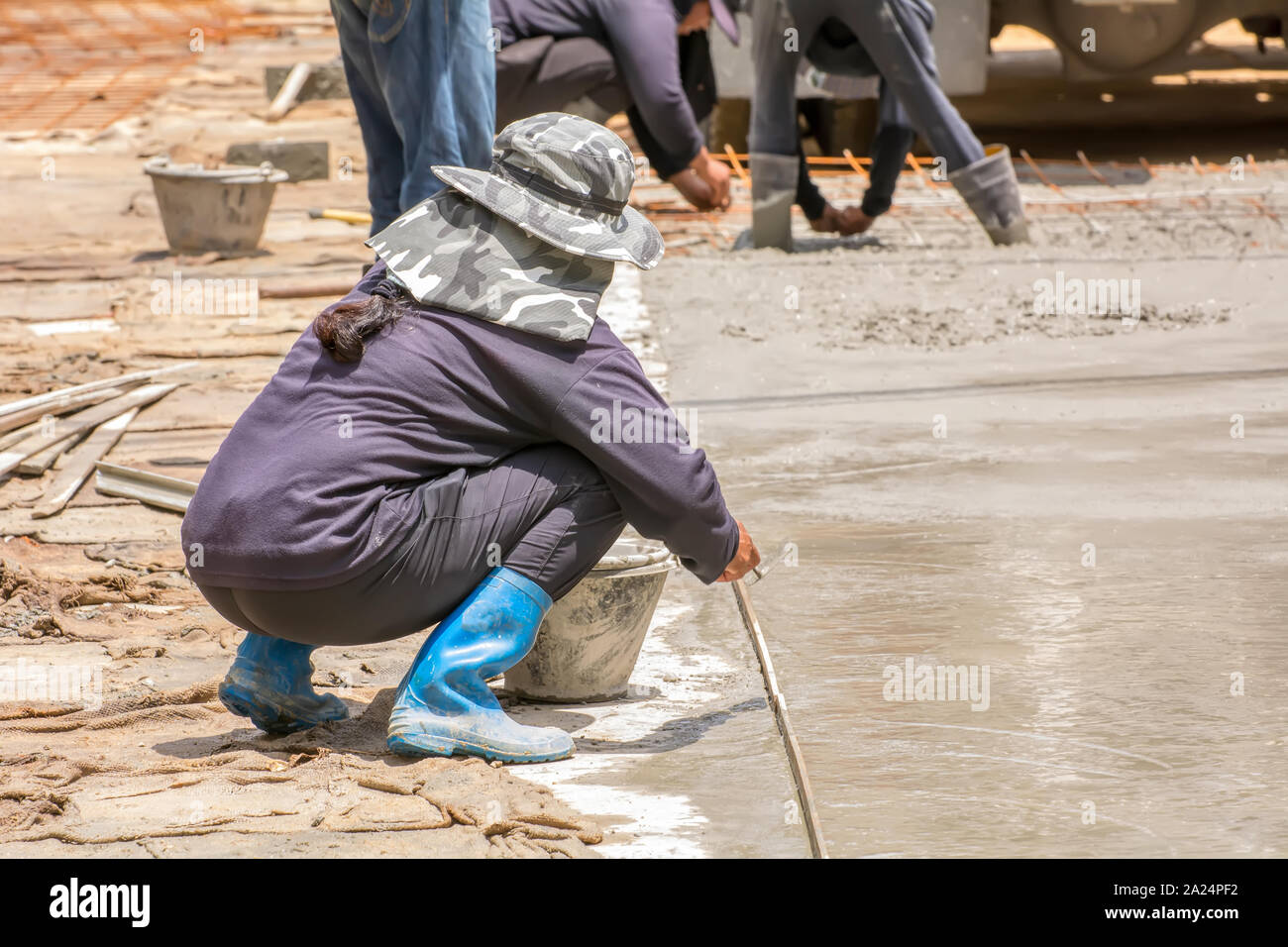 Construction worker pouring cement for doing the road Stock Photo - Alamy