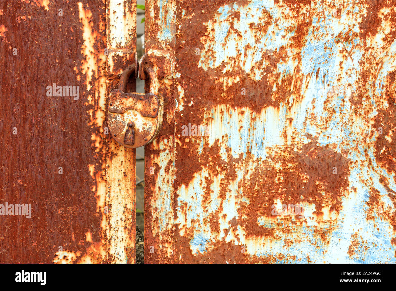 An old rusty door lock and an old metal sheet with rust texture and ...