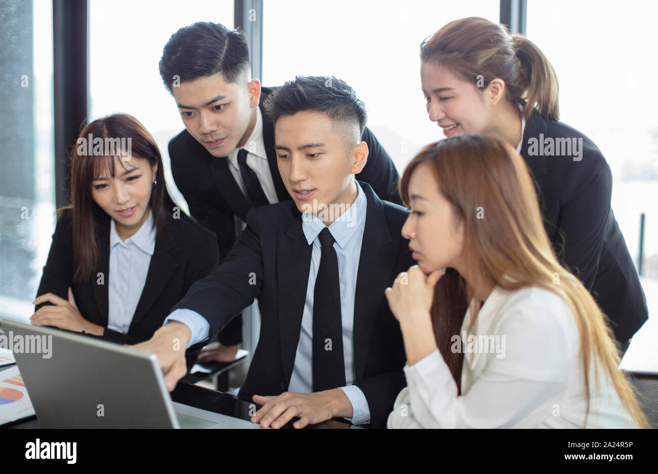 business people looking at the laptop computer and talking during ...
