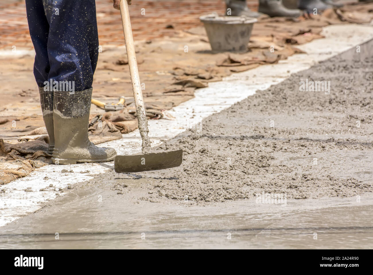 Construction worker pouring cement for doing the road Stock Photo - Alamy