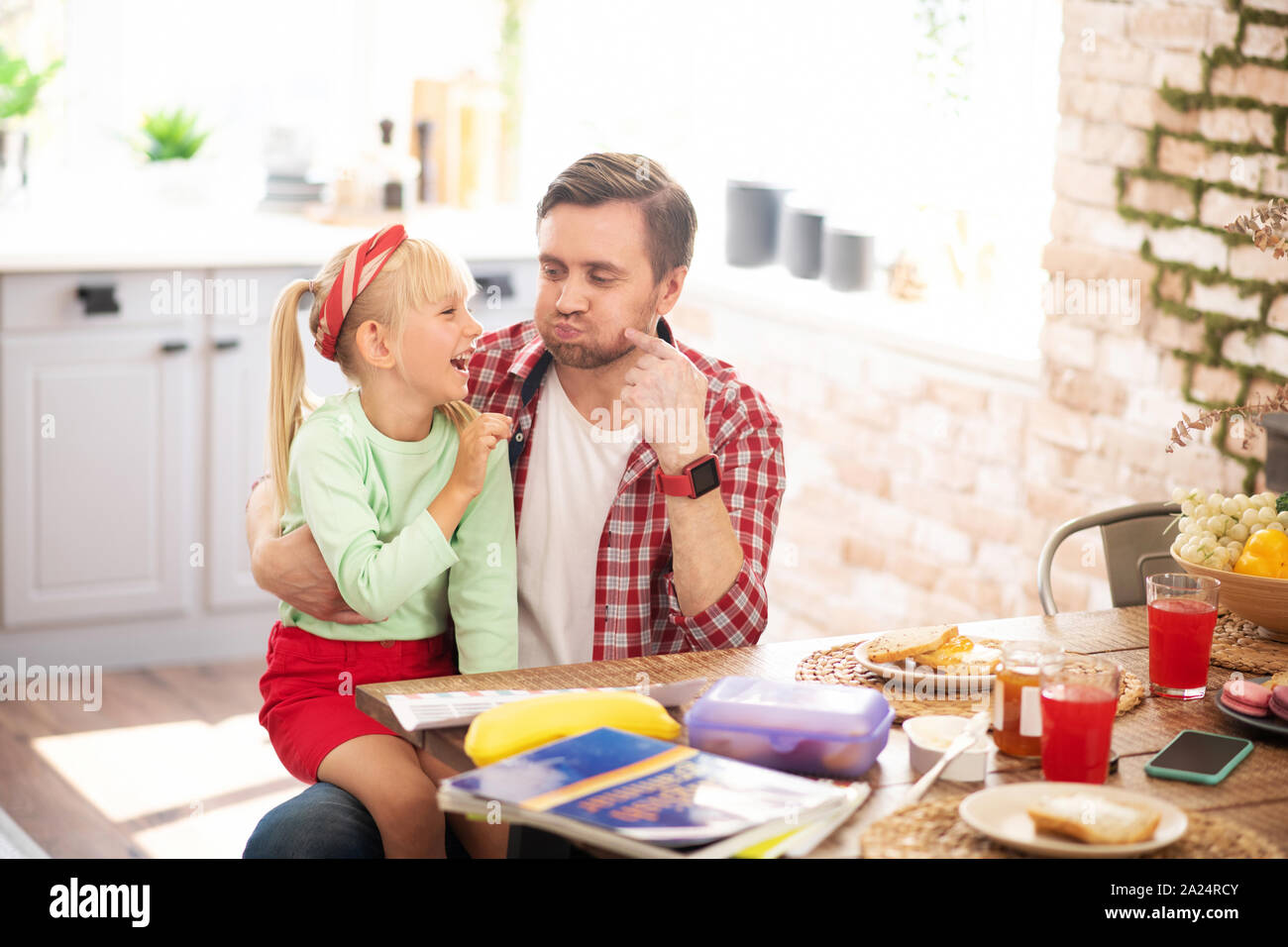 Father making funny face while having fun with laughing daughter Stock ...