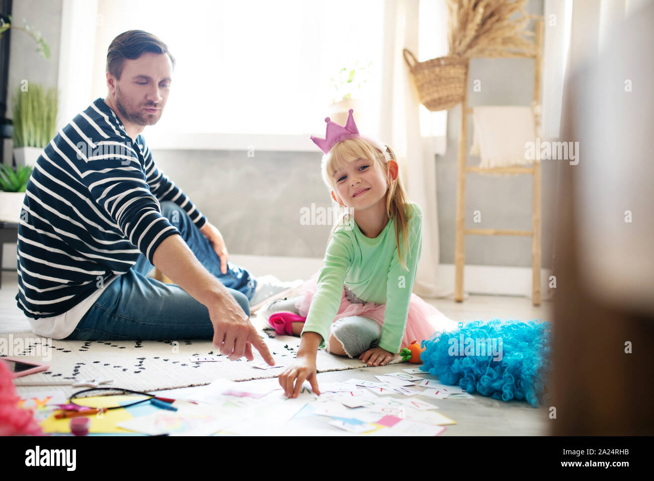 Cute girl feeling involved in studying with daddy Stock Photo - Alamy
