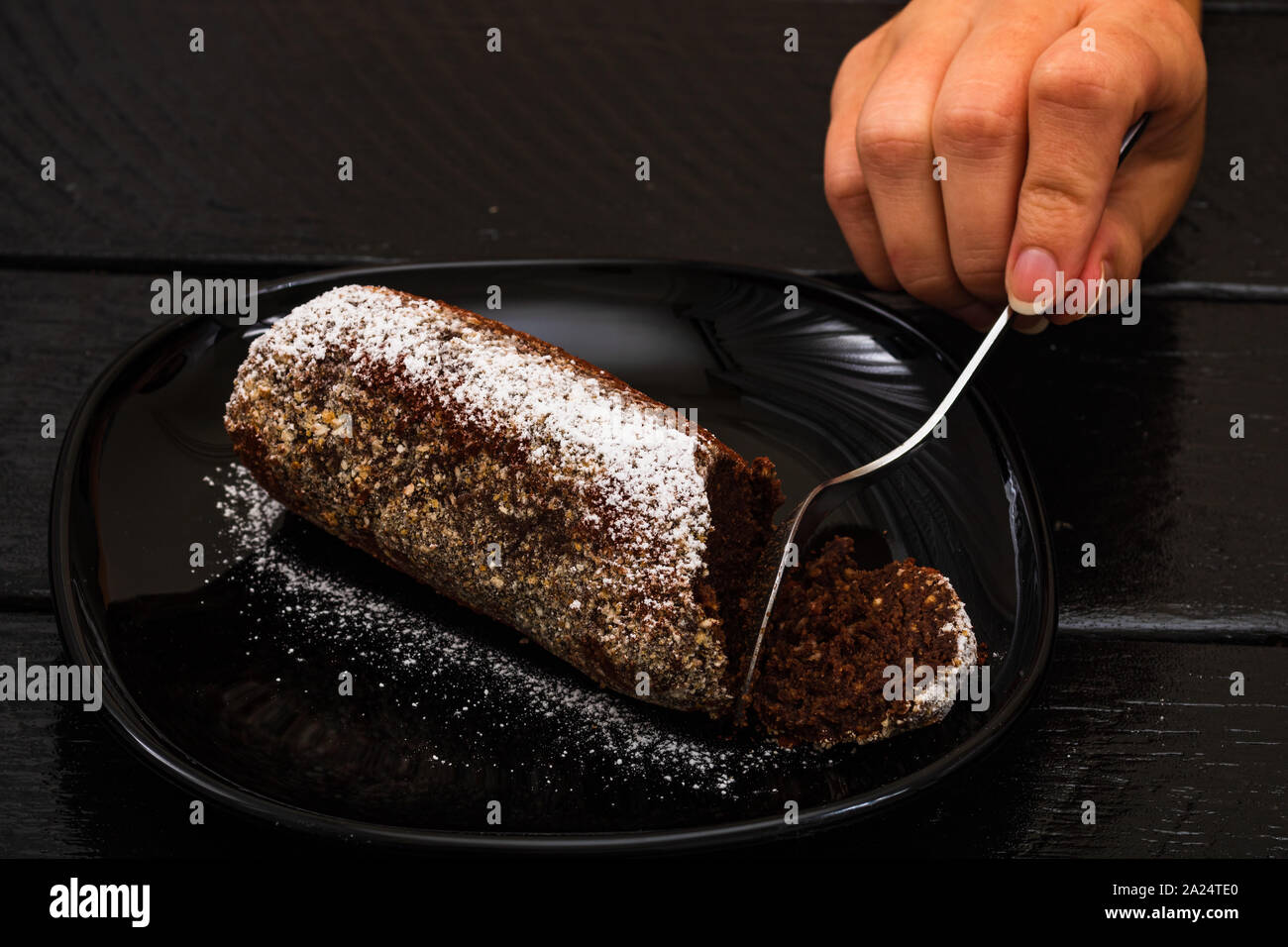 Eating cocoa cake with sugar powder. Close up photo Stock Photo - Alamy