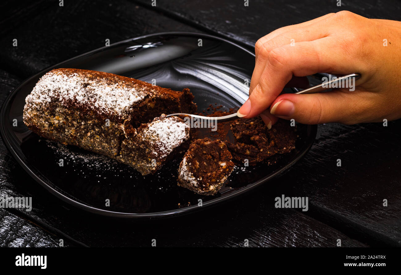 Eating cocoa cake with sugar powder. Close up photo Stock Photo - Alamy
