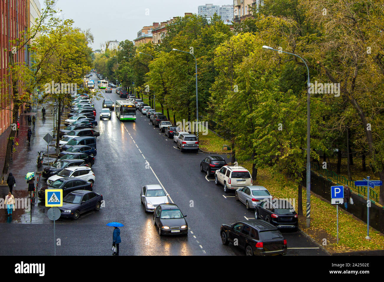 calm city street with cars and pedestrians in the rain Stock Photo - Alamy