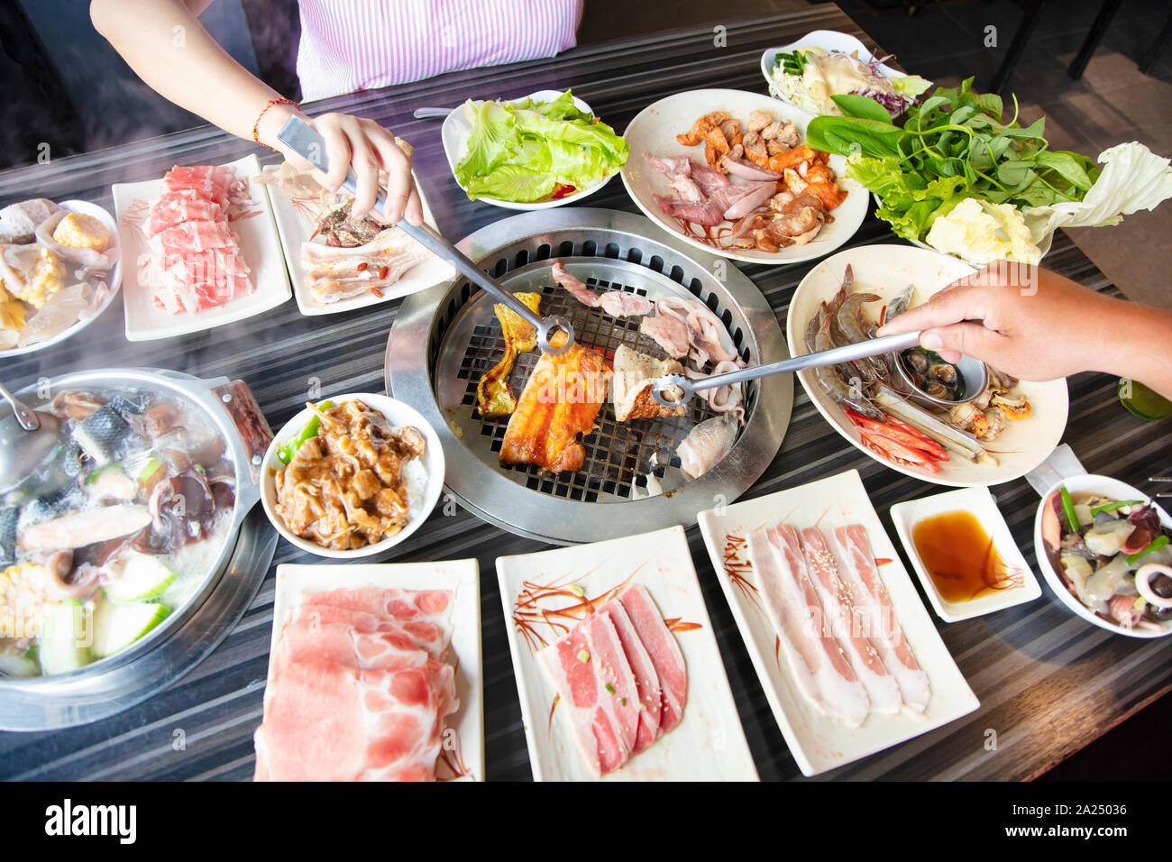 people eating barbecue beef in restaurant Stock Photo - Alamy