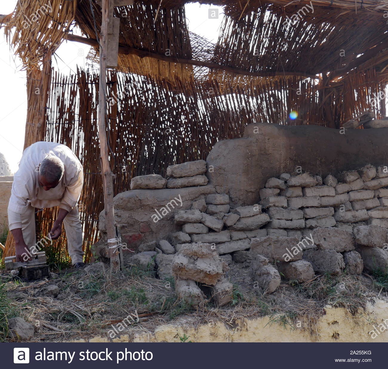 Re-enactment of an ancient Egyptian, brick maker, preparing bricks for ...