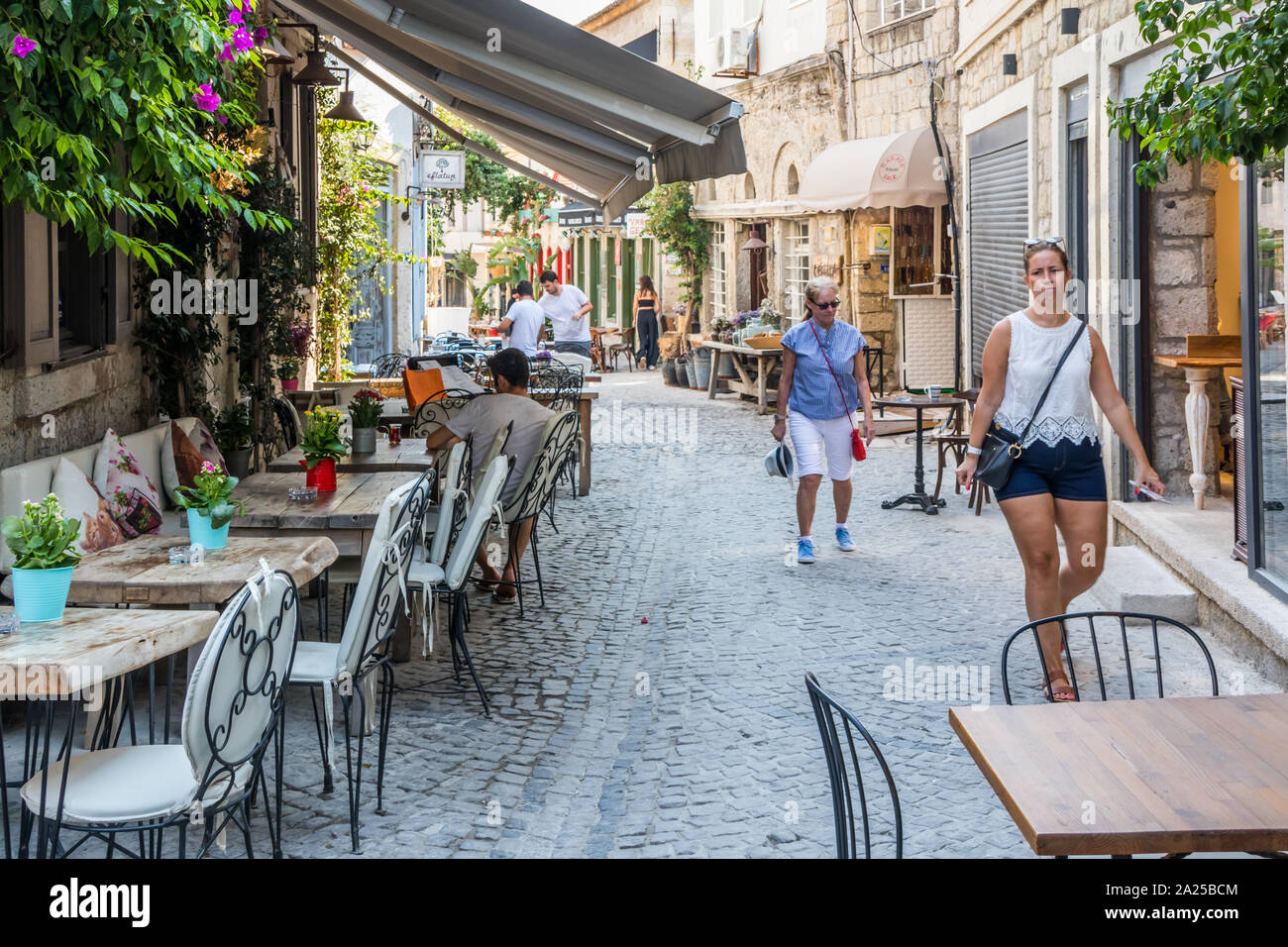 Alacati, Turkey - September 4th 2019: Tourists walking down a narrow ...