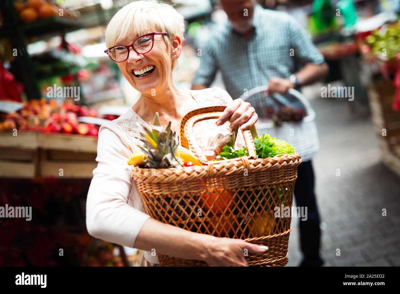 Only the best fruits and vegetables. Beautiful mature woman buying ...