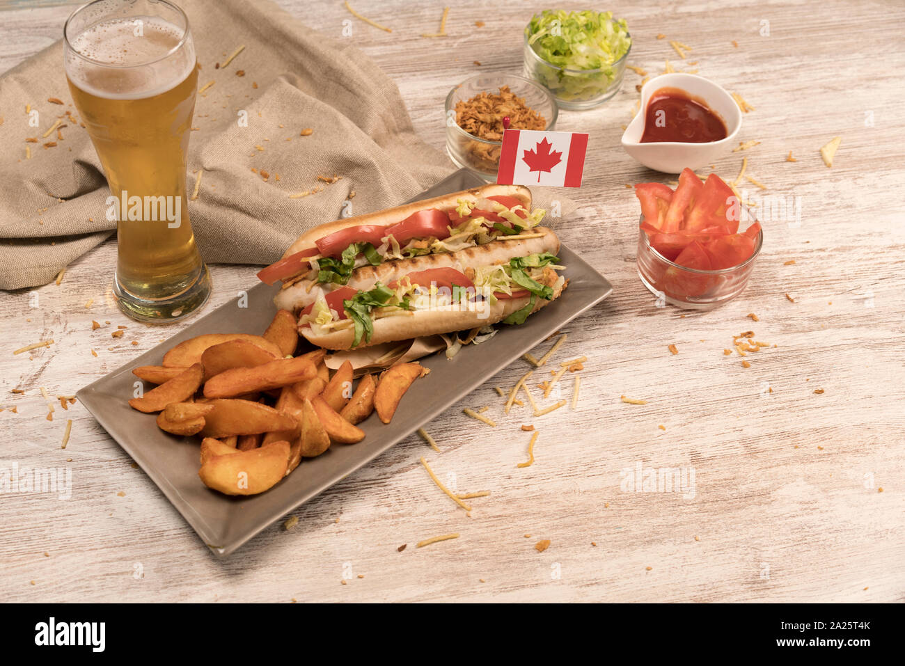 Homemade hot dog on white wooden board with various condiments top view ...