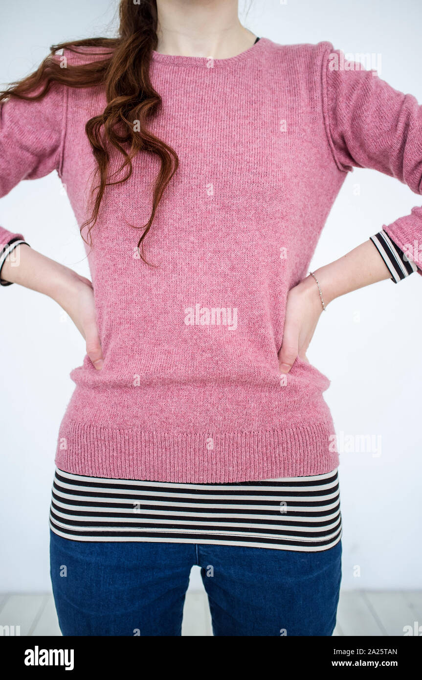 Slim young girl standing with arms akimbo on a white background Stock ...
