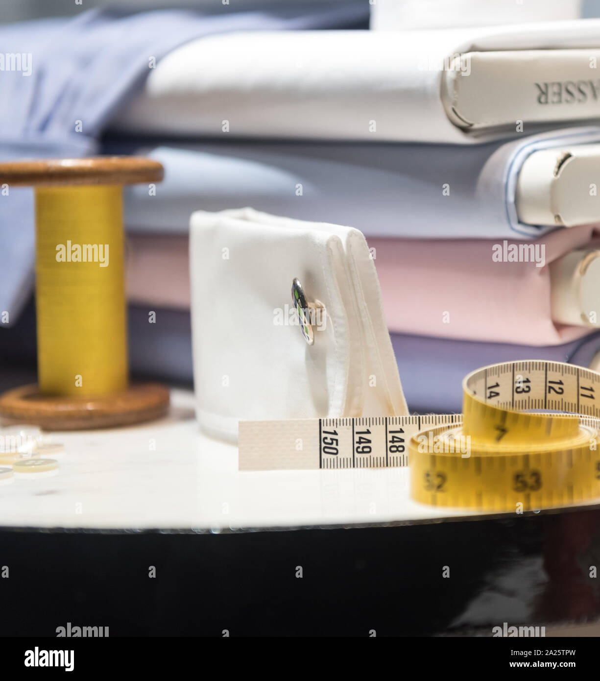Tailor's Table with Thread and Tape Measure and Shirt Cloth Swatches ...