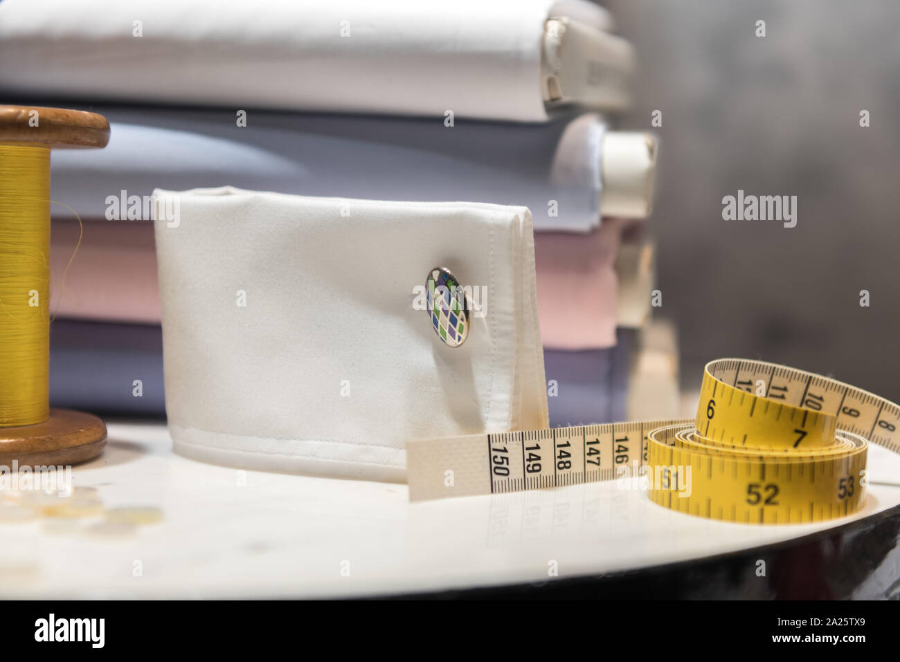 Tailor's Table with Thread and Tape Measure and Shirt Cloth Swatches ...