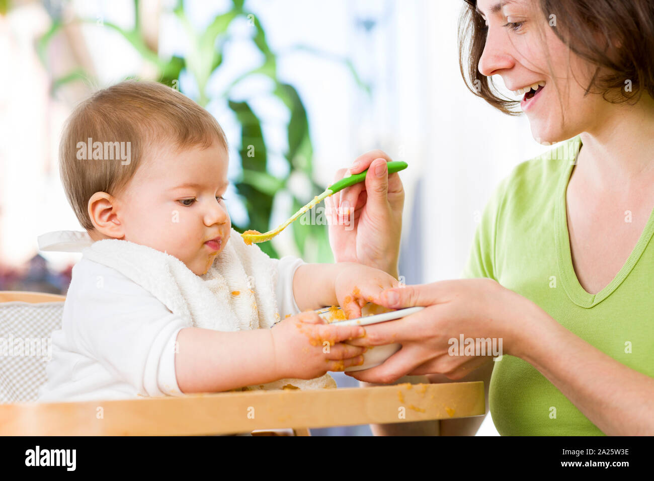 Lovely baby boy playing with food while eating Stock Photo - Alamy
