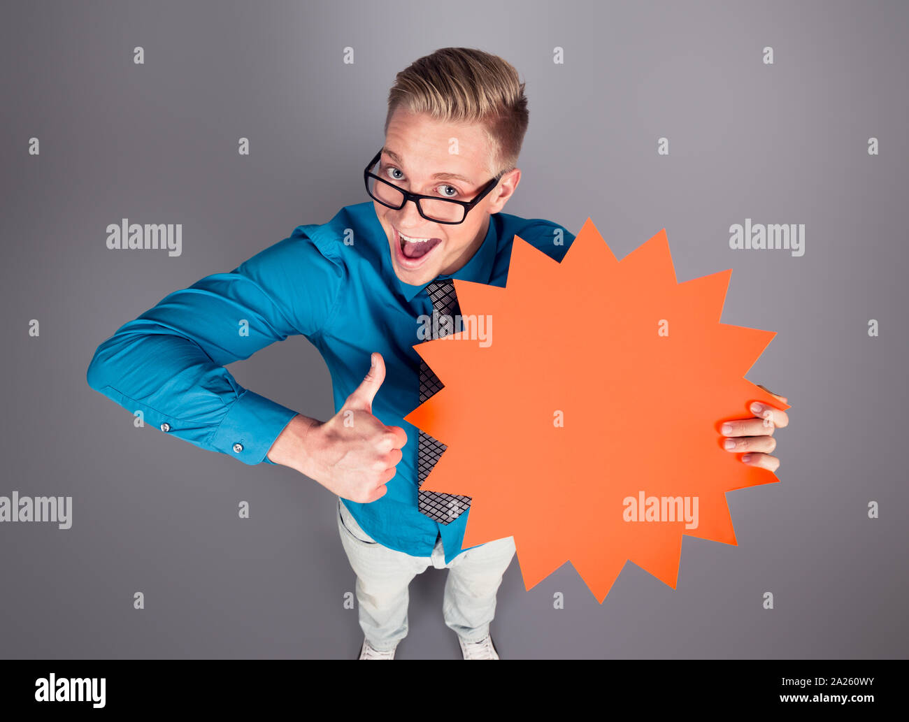 Salesman with thumbs up and empty sign promoting sales Stock Photo - Alamy
