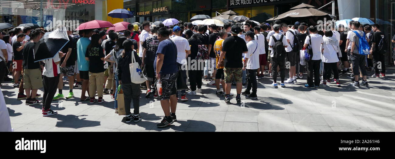 Young fashionable Chinese crowd gathers outside a store to take part in ...