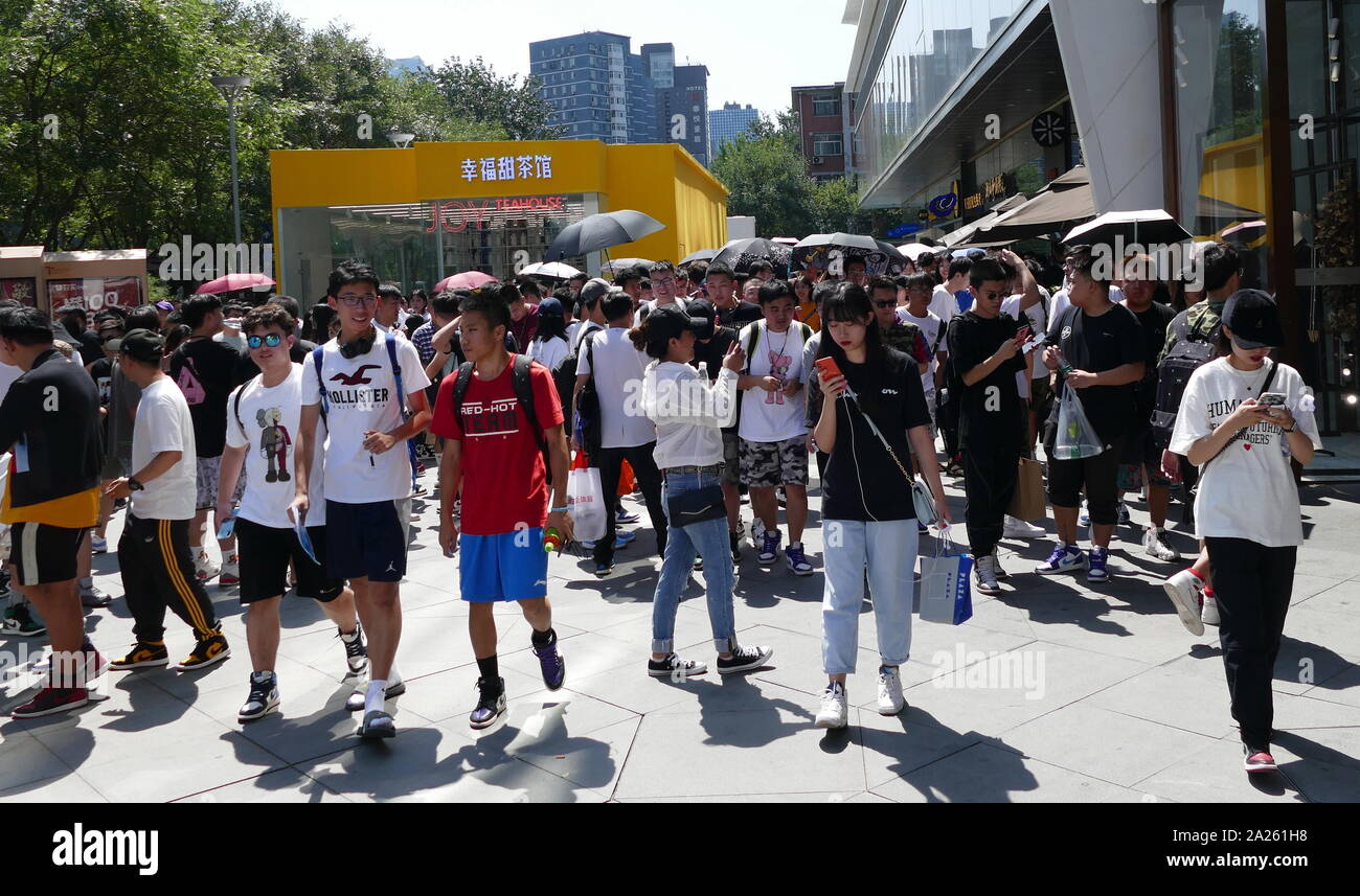 Young fashionable Chinese crowd gathers outside a store to take part in ...