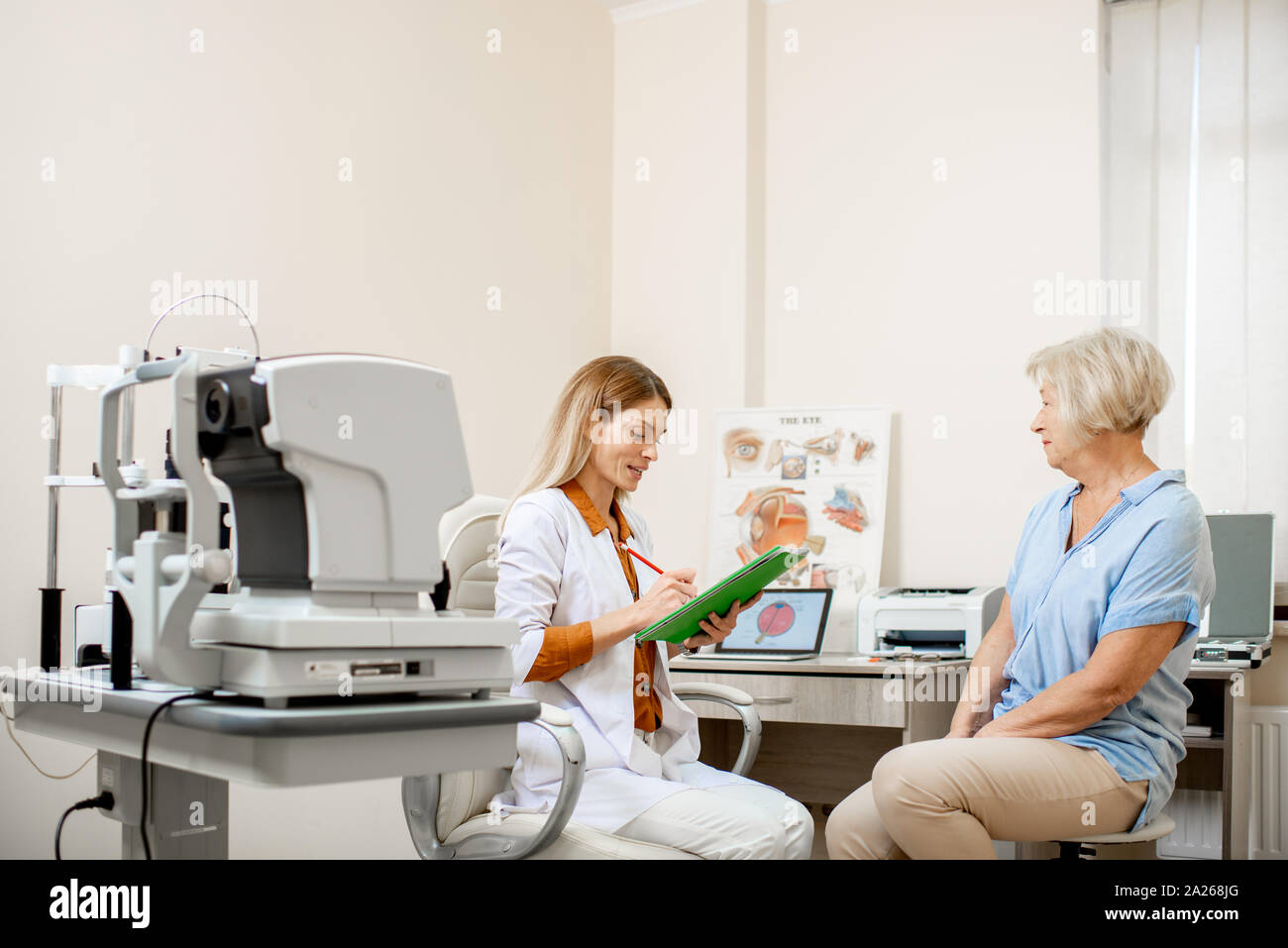 Senior woman patient talking with female ophthalmologist during a ...