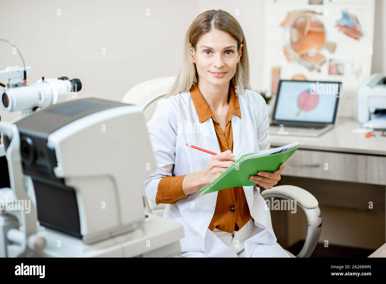 Portrait of a beautiful female ophthalmologist writing a medical recipe ...