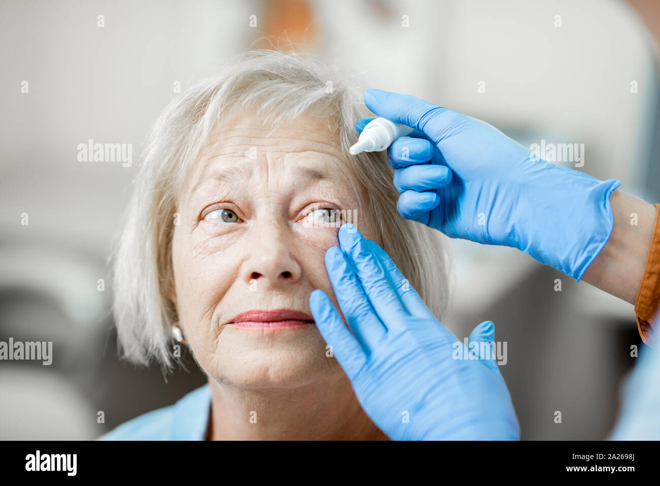 Old woman putting eye drops hi-res stock photography and images - Alamy